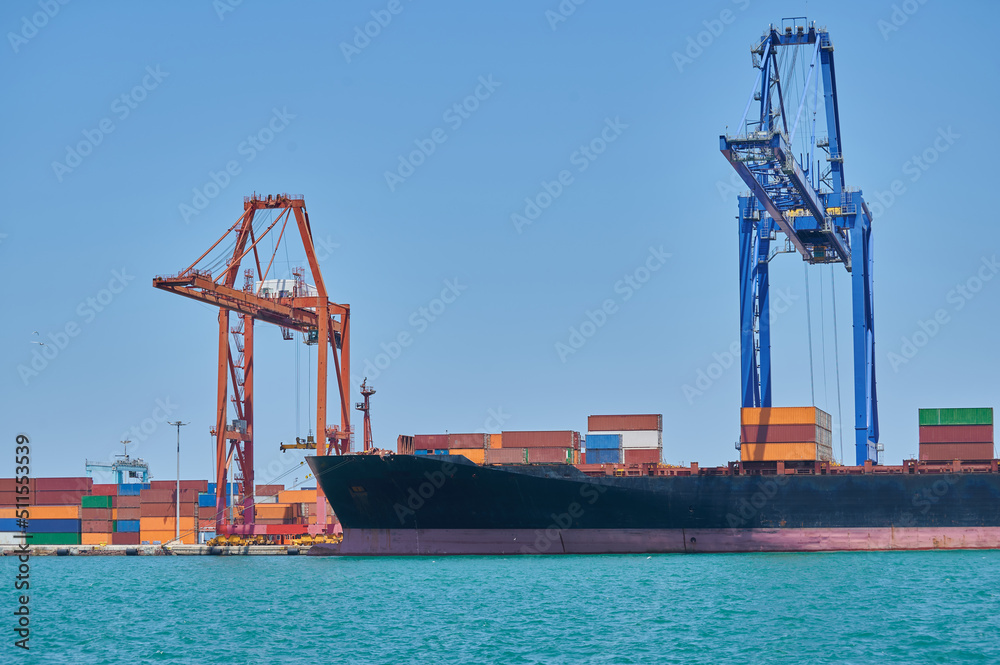 Port crane loading and unloading containers onto a ship. Maritime trade ...