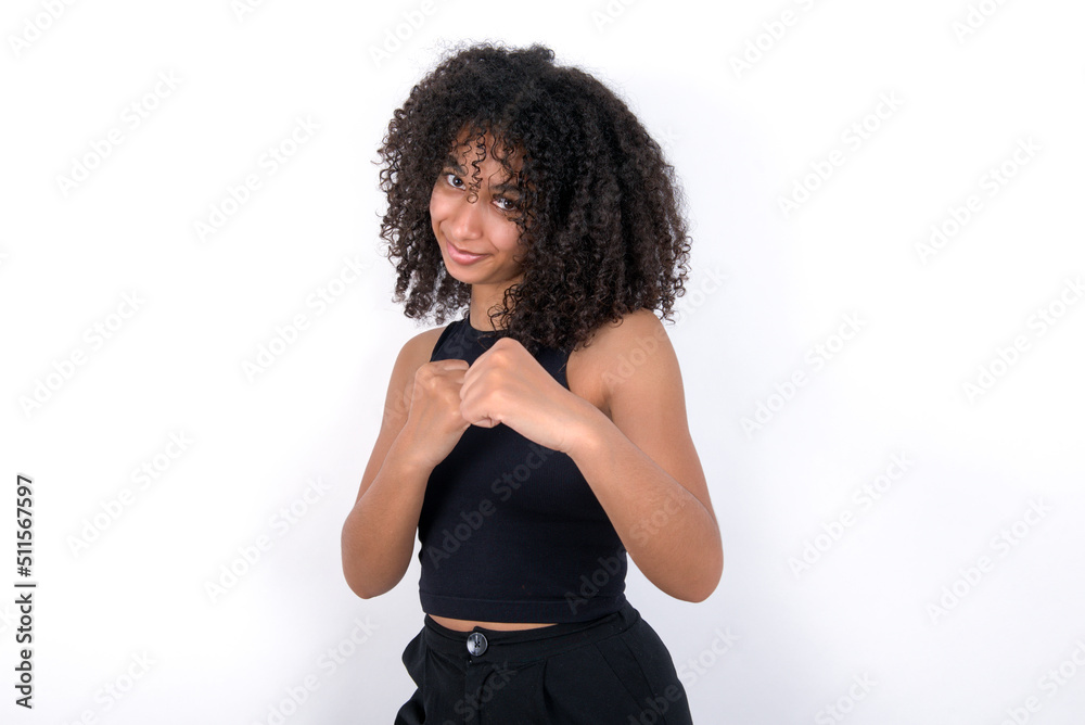 Young beautiful girl with afro hairstyle wearing black tank top over ...