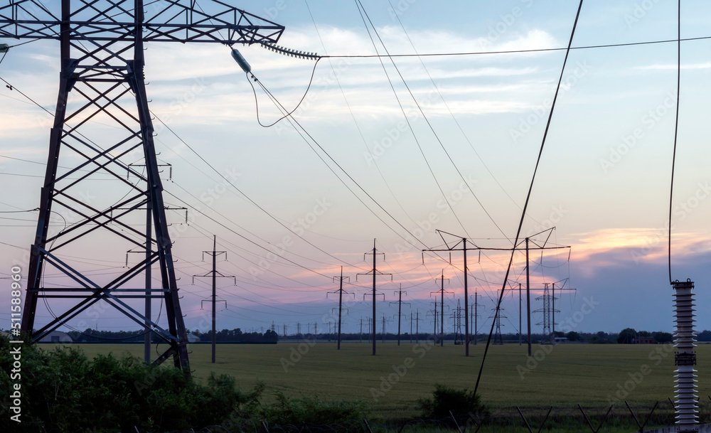 Power lines in the orange sunset sky. Power lines and evening sunset ...