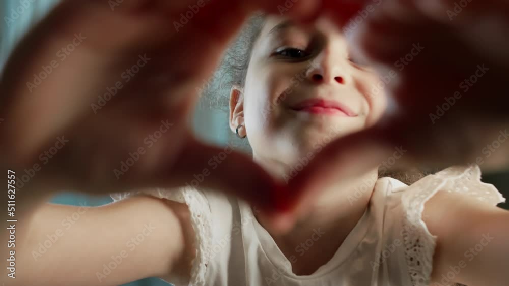 Affectionate happy cute adorable kid girl child make heart shape hand ...