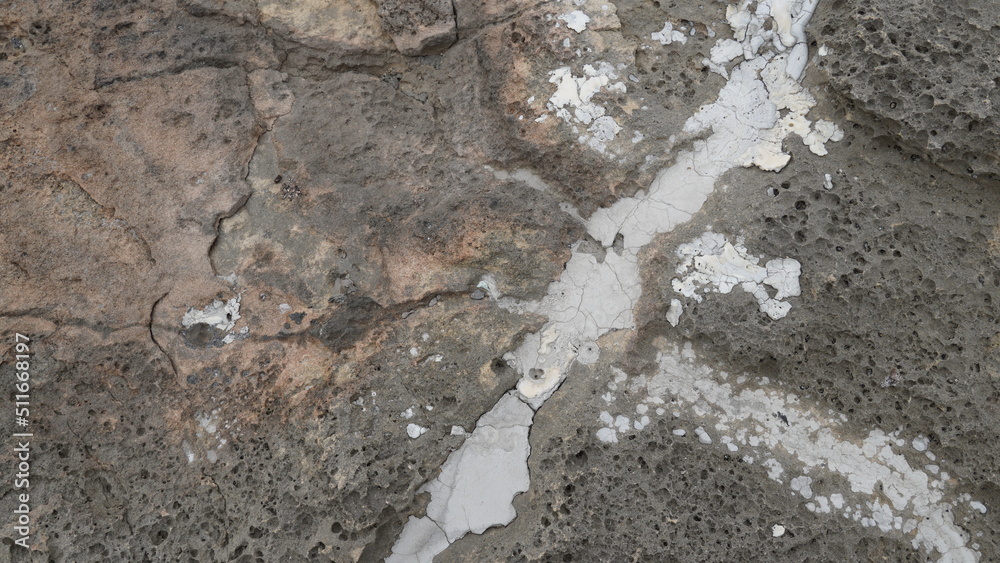 Volcanogenic rock slabs on the seashore. Natural rocky breakwater at ...