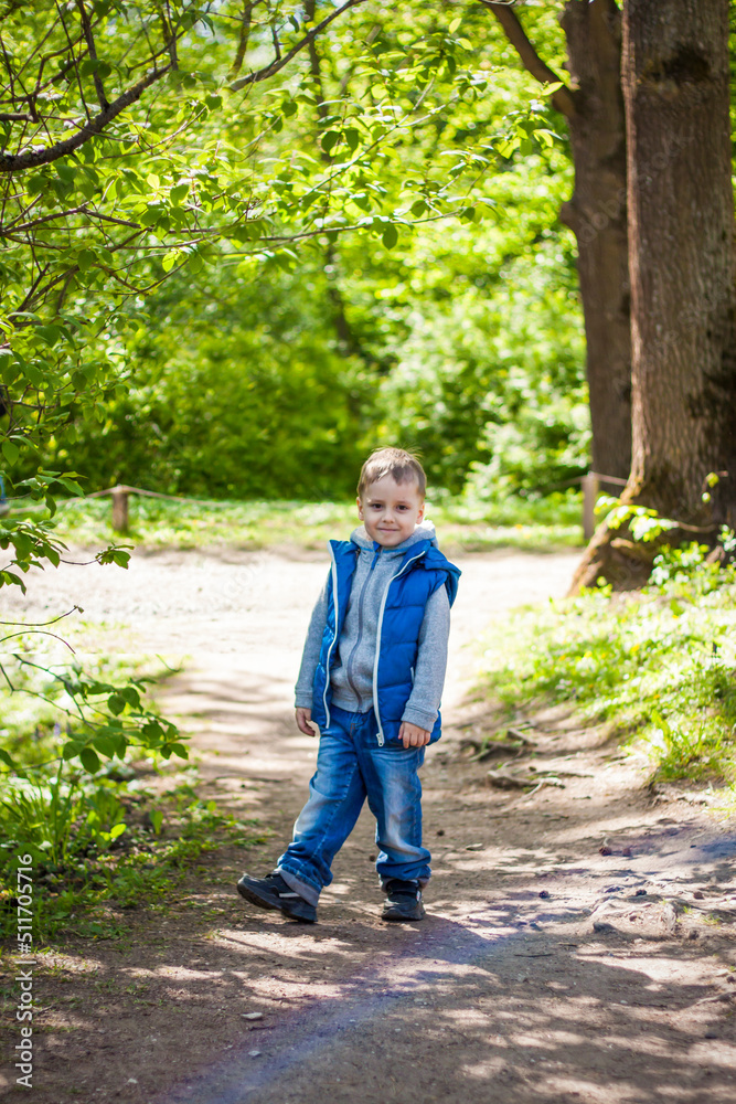 Portrait of a boy in the forest in spring. Take a walk in the green ...