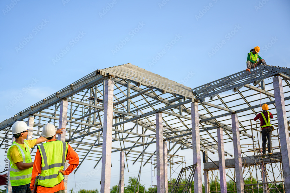 A team of male engineers working at a house construction site. Discuss ...