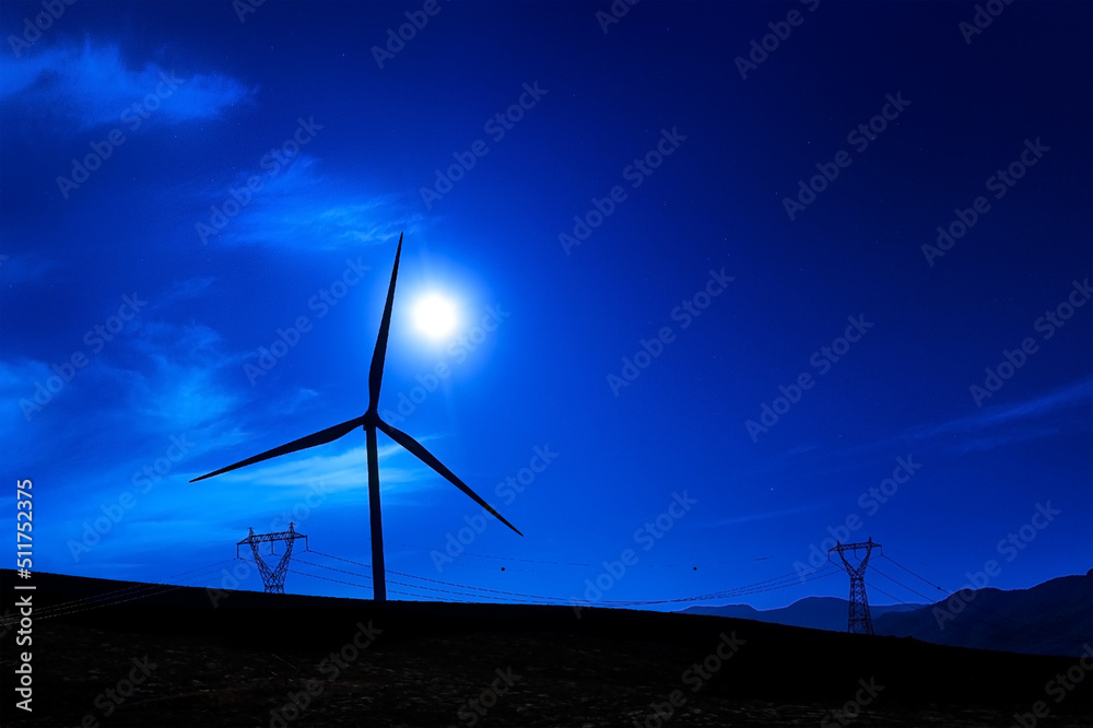 View of wind turbine at full moon. Wind power or wind energy is mostly ...