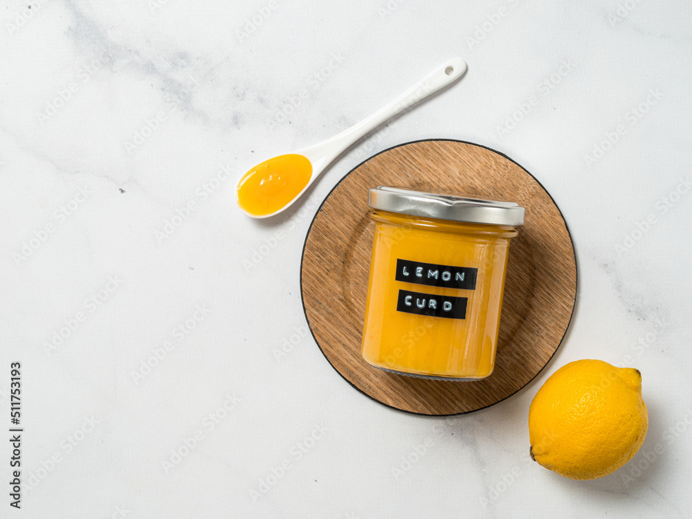 Delicious homemade lemon curd. Glass jar with lemon curd and full spoon ...