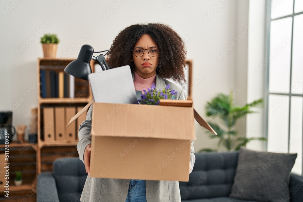 Young african american woman moving to a new office holding box with ...
