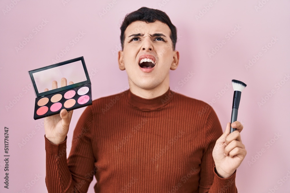 Non binary person holding makeup brush and blush angry and mad ...