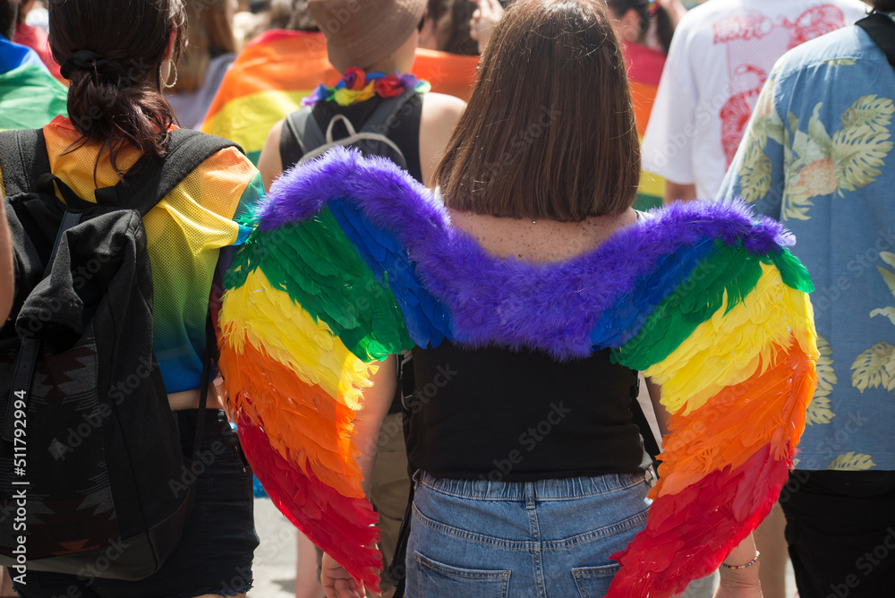Portrait on back view of young woman wearing a rainbow angel wings ...