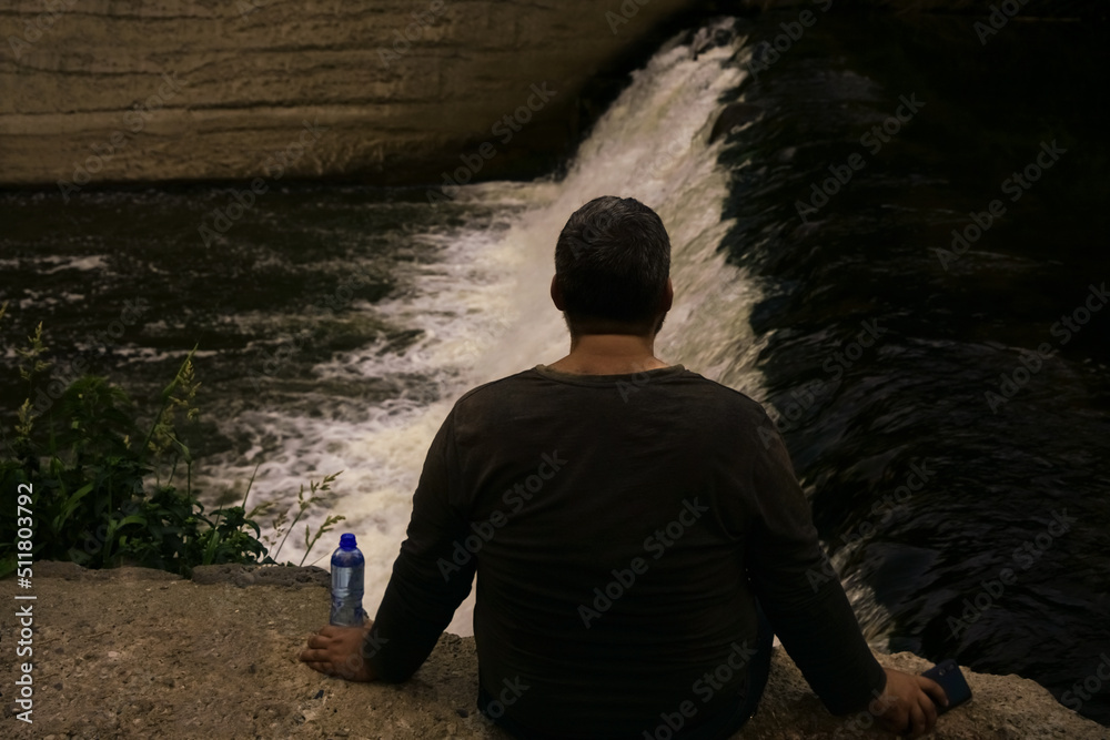relax in nature concept. Man with mobile phone and bottle of water ...