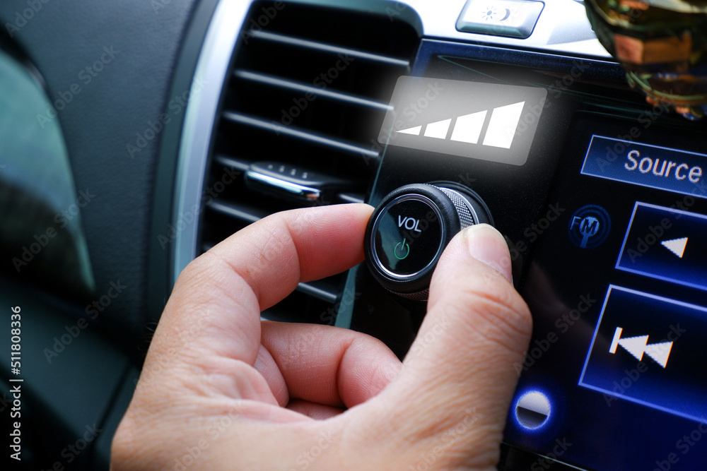 Photo & Art Print Driver hand adjust volume control on the car radio ...