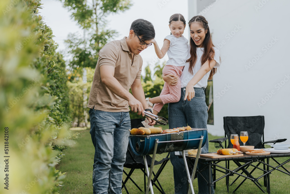 Asian Family Having Dinner In The Backyard At Home Happy With Little ...