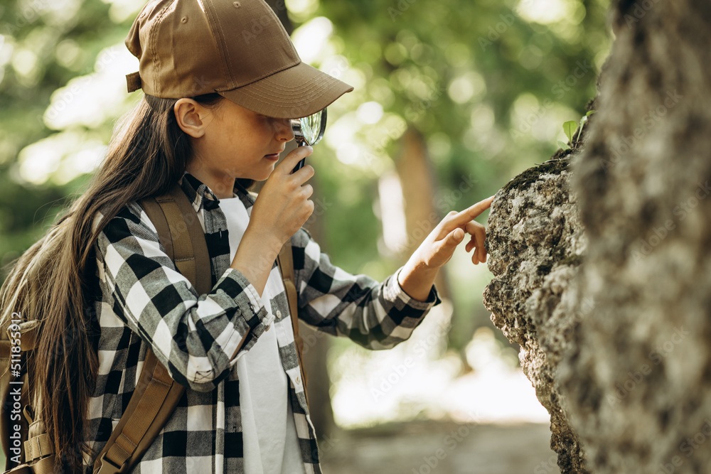 Girl scout looking through magnifying glass on the rock Stock Photo ...