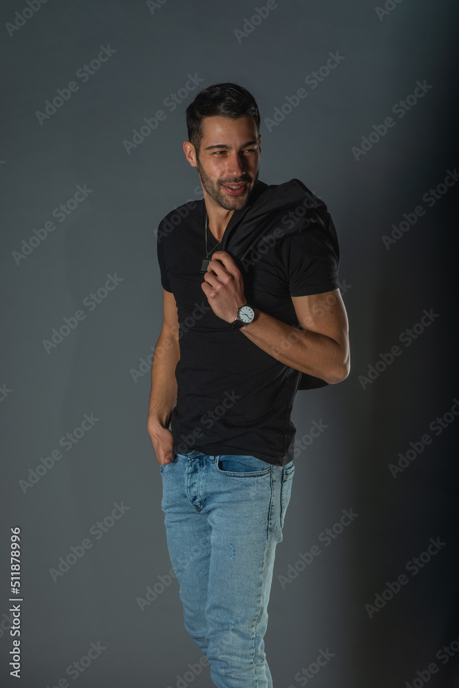 Strong muscular male model in jeans with black t-shirt holding his ...