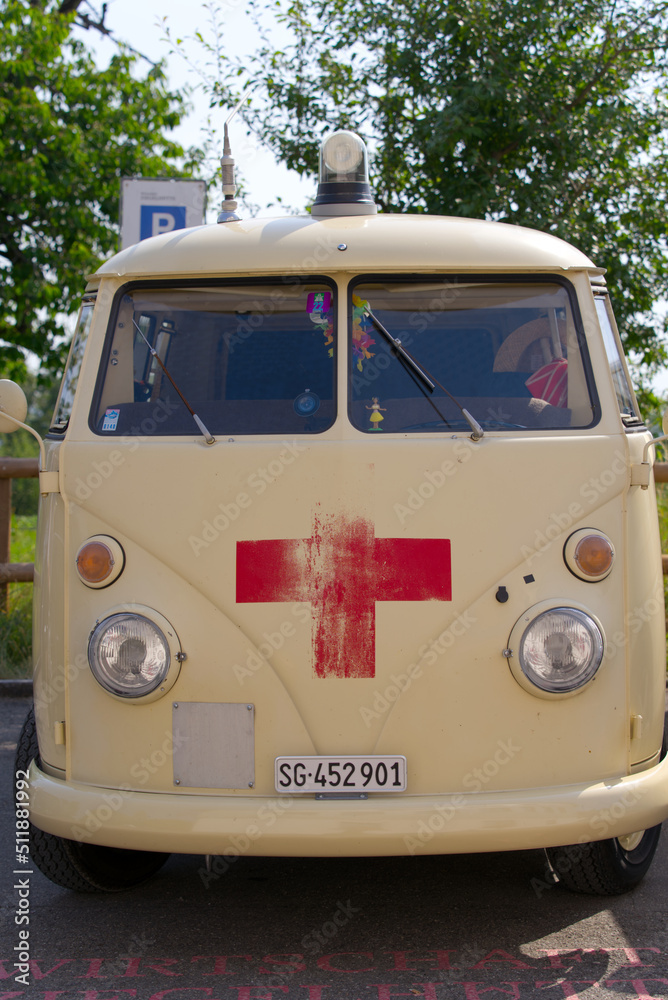 Ochre classic ambulance car VW Bus with red cross and blue light at car ...