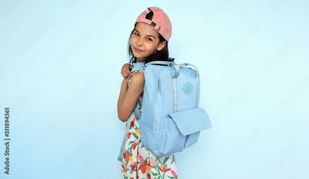 Rear view of a cute kid smiling wearing colorful dress, pink cap, and ...