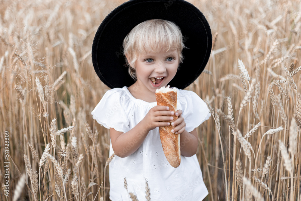 Beautiful portrait of a young child in a field. Children with bread ...