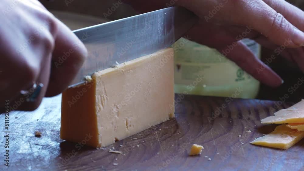 A 4K slow motion video of cheese being sliced at home in preparation ...