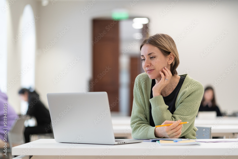 Middle-aged woman using laptop computer for e-learning, mature female ...