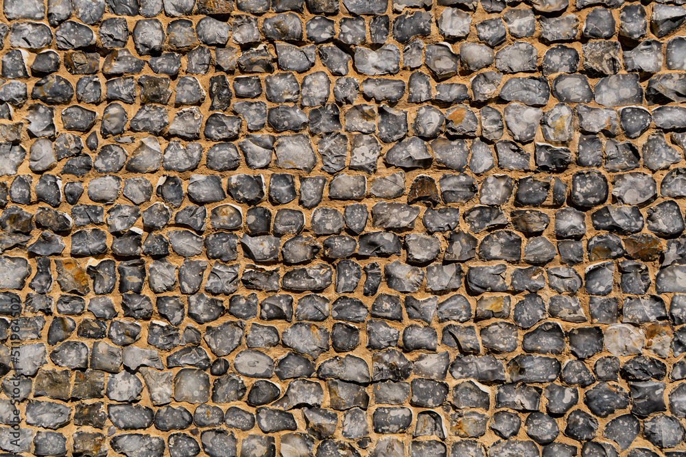 View of a big wall made of flint stones, building material in ...