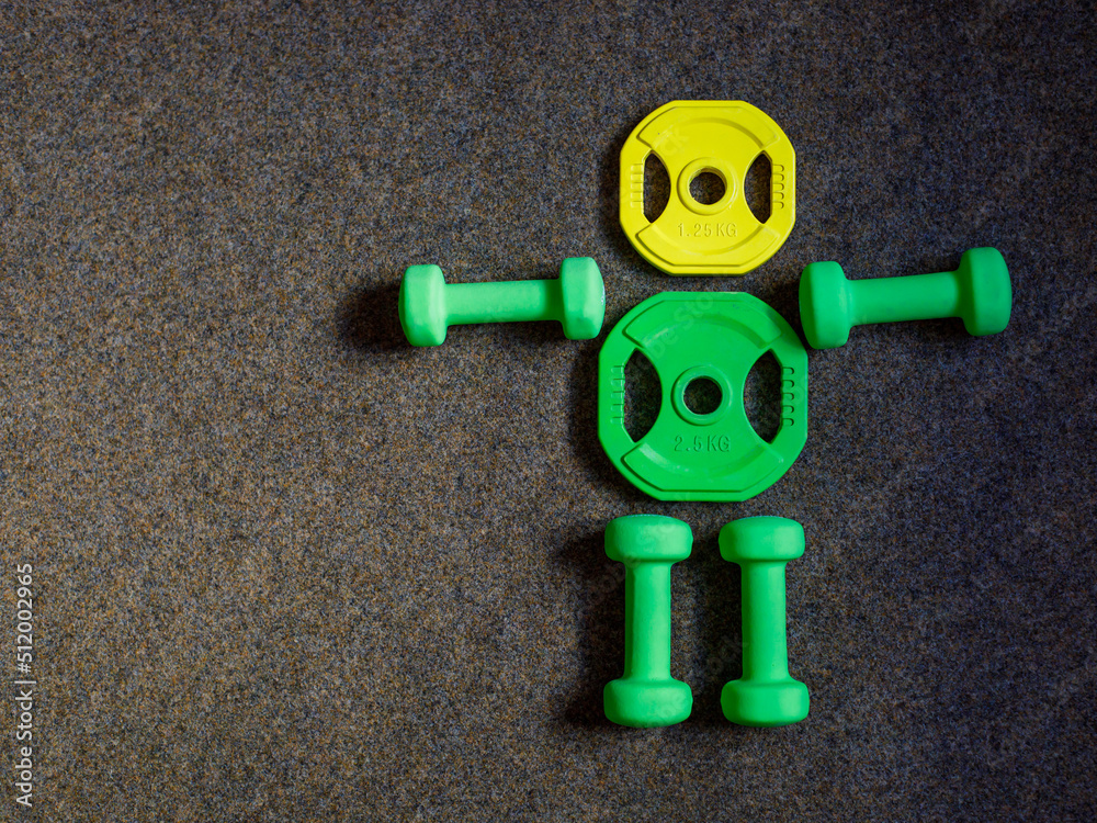 Green heavy dumbbells and yellow barbell metal weight disc in shape of ...