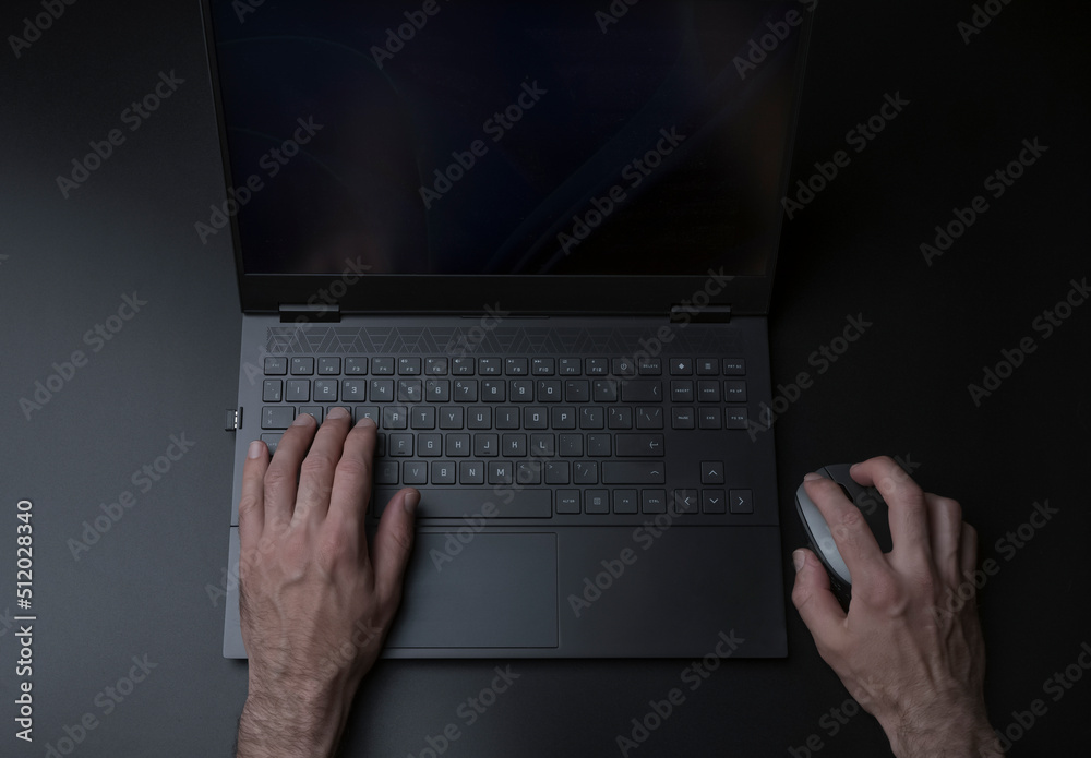 Laptop computer keyboard with user or gamer hands on black stylish ...
