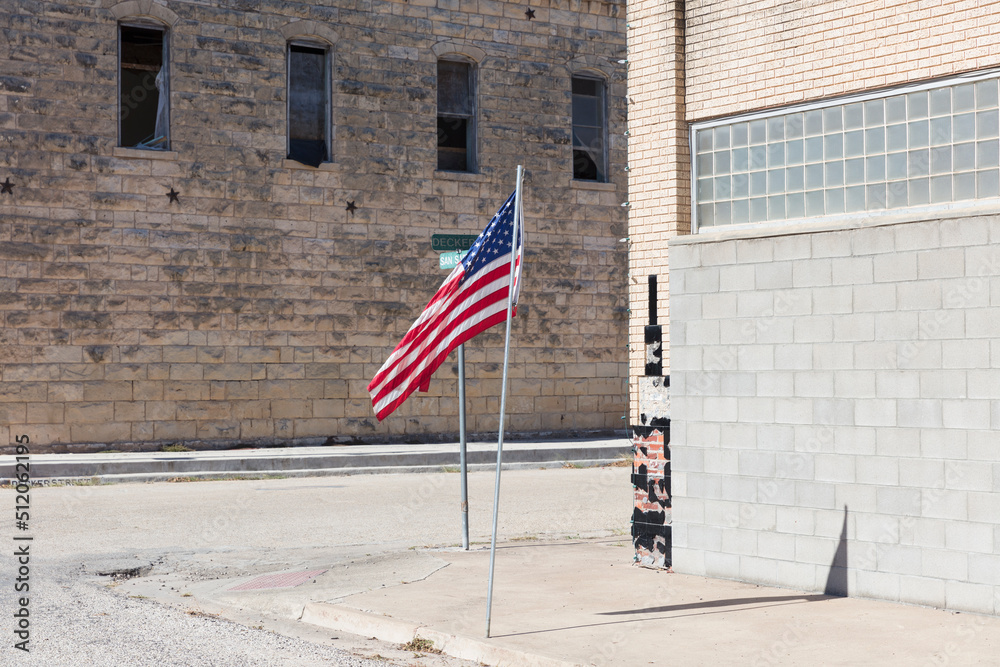 American flag flying outside a building on a main street. Stock Photo ...