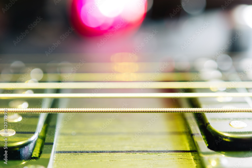 Details of the body and fretboard of an electric guitar. Stage lighting ...