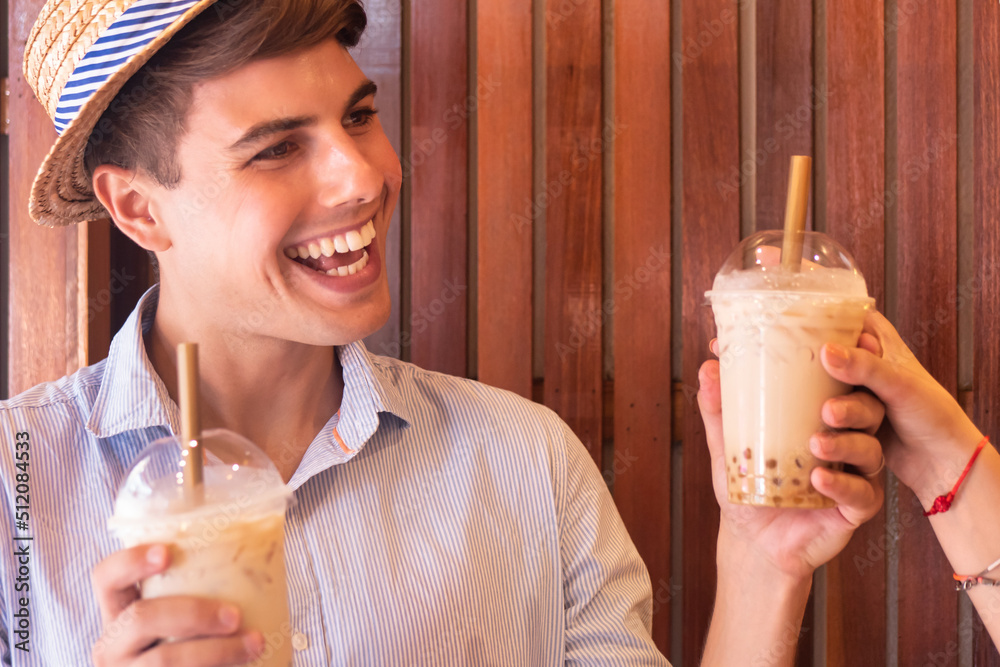 Happy man traveler sharing Asian boba milk tea with his friend Stock ...