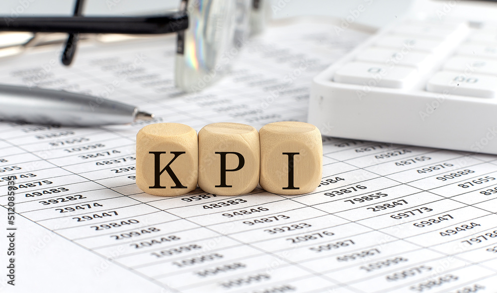 wooden cubes with the word KPI stand on a financial background with ...
