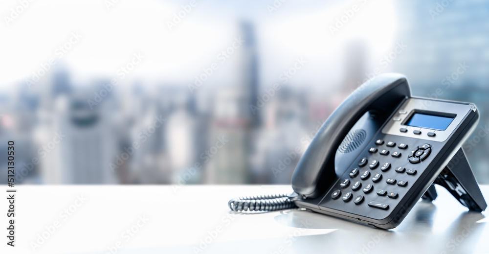 telephone with VOIP on white table on blurred city background. customer ...