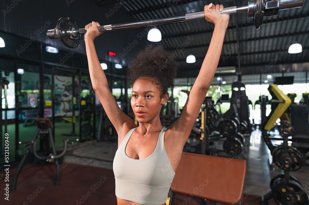 African American woman bodybuilder training back doing deadlift with ...