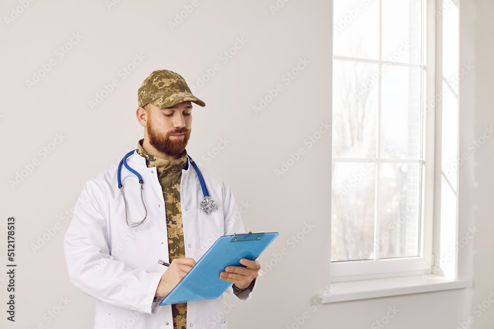 Foto de Military doctor inside the hospital. Man with ginger beard ...