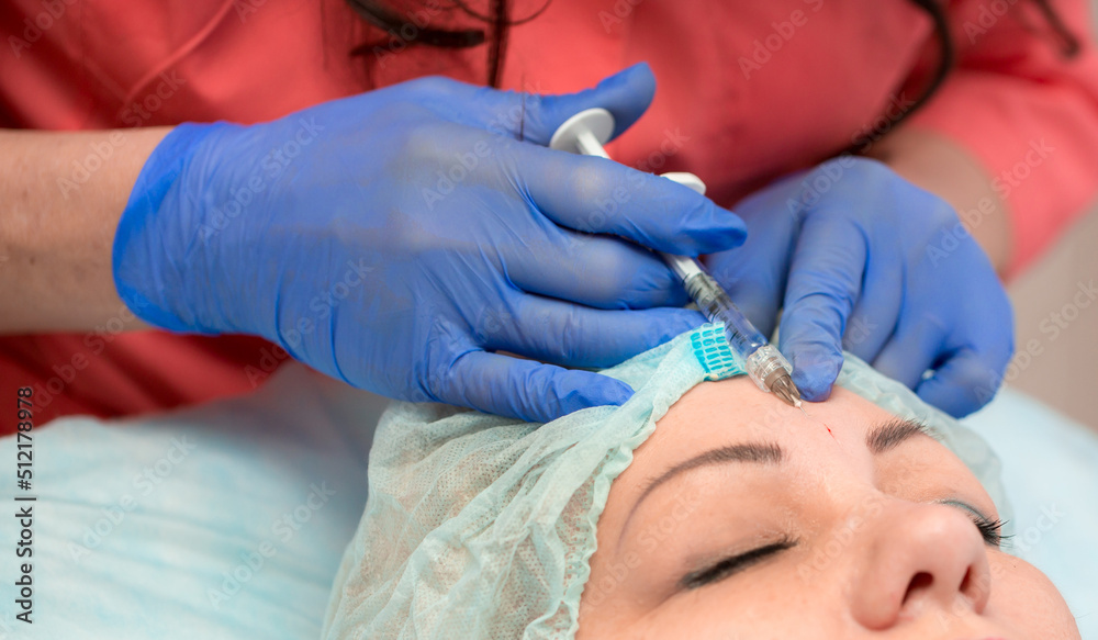 Injection facial rejuvenation. The cosmetologist injects cosmetic ...