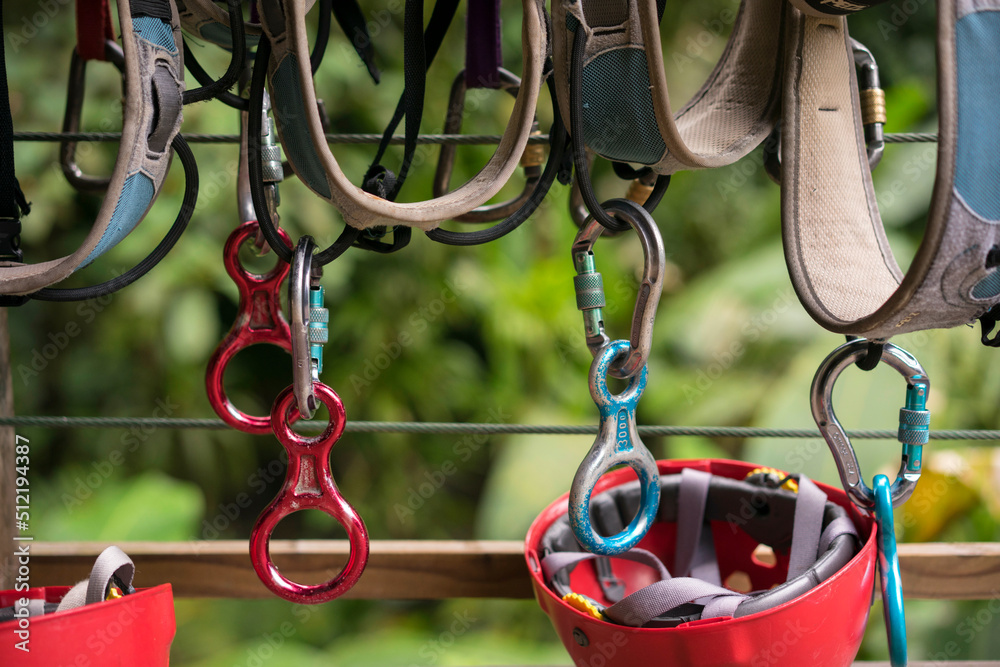 Climbing harnesses and helmets hanging on wire Stock Photo | Adobe Stock