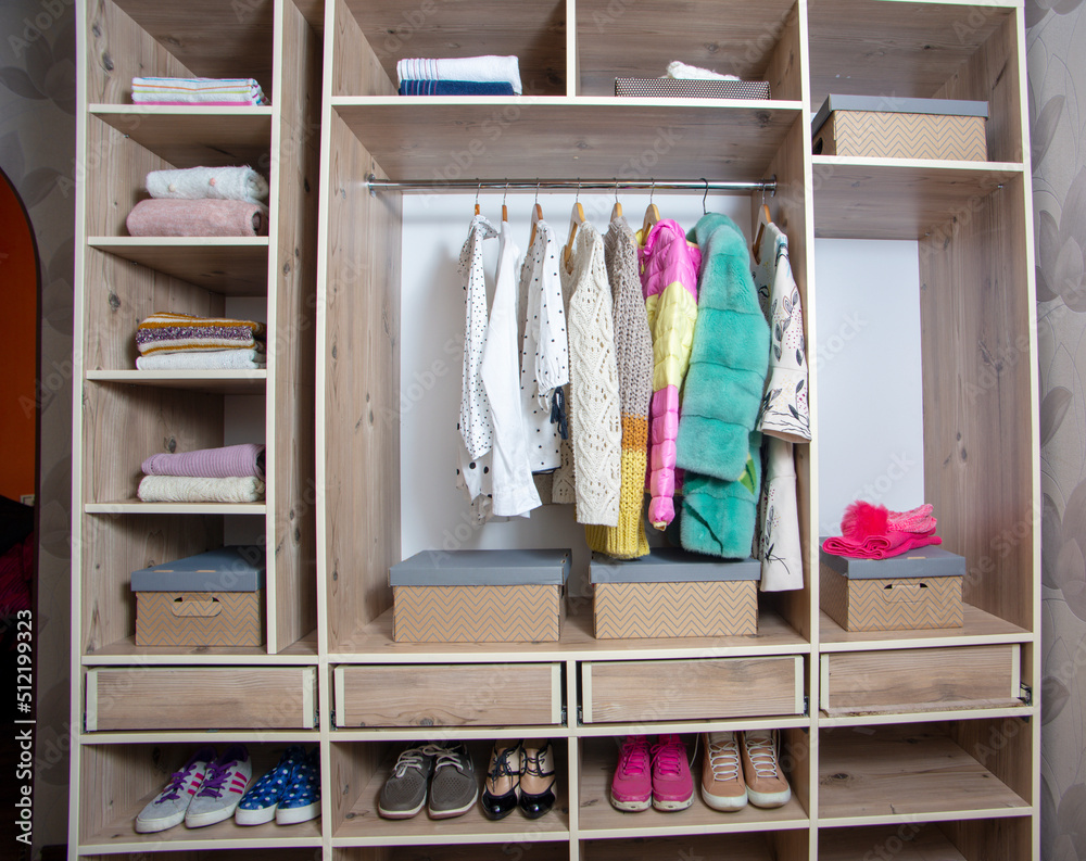 Big wardrobe with different clothes and accessories in dressing room ...