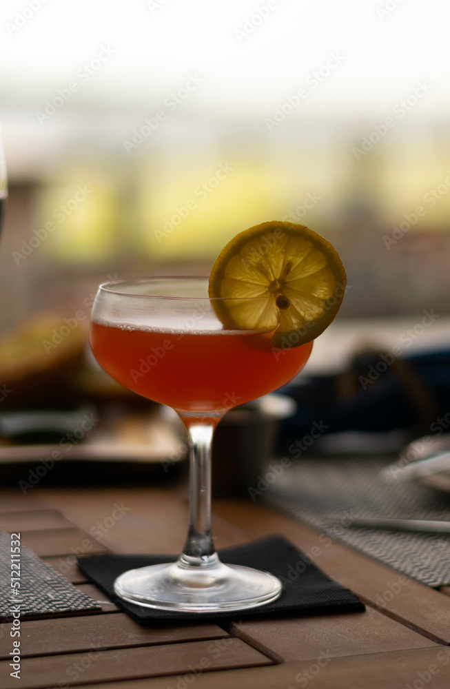 Red Devil Battery vodka cocktail in a dinner setting with unfocused ...