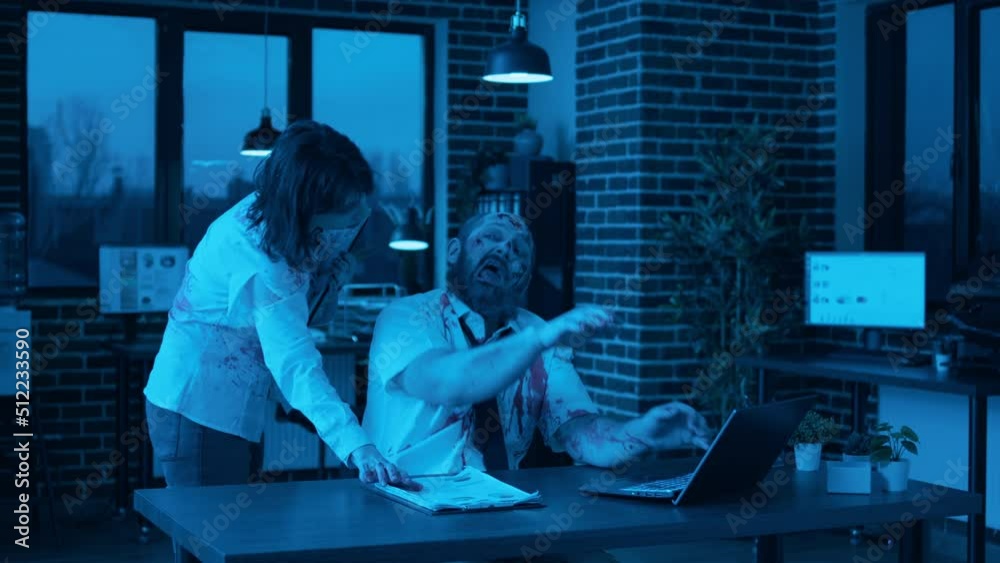 Creepy mindless zombie sitting in office while working on modern laptop ...