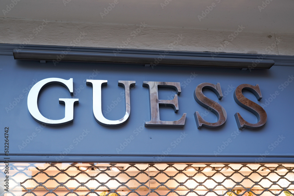 guess logo facade and sign text on storefront wall entrance shop luxury ...