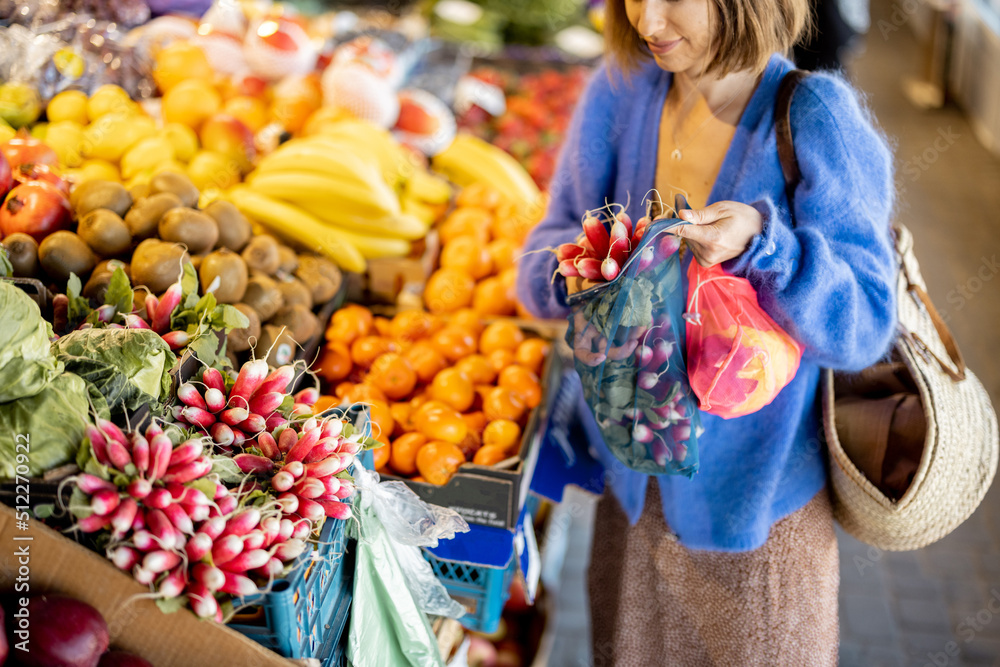 Woman takes a bunch of radishes from the counter, buying fresh ...