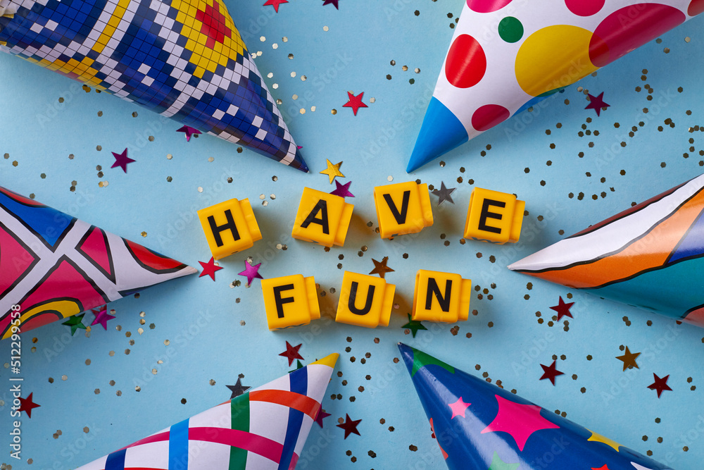 Have fun words with colorful birthday cones. Confetti on blue ...