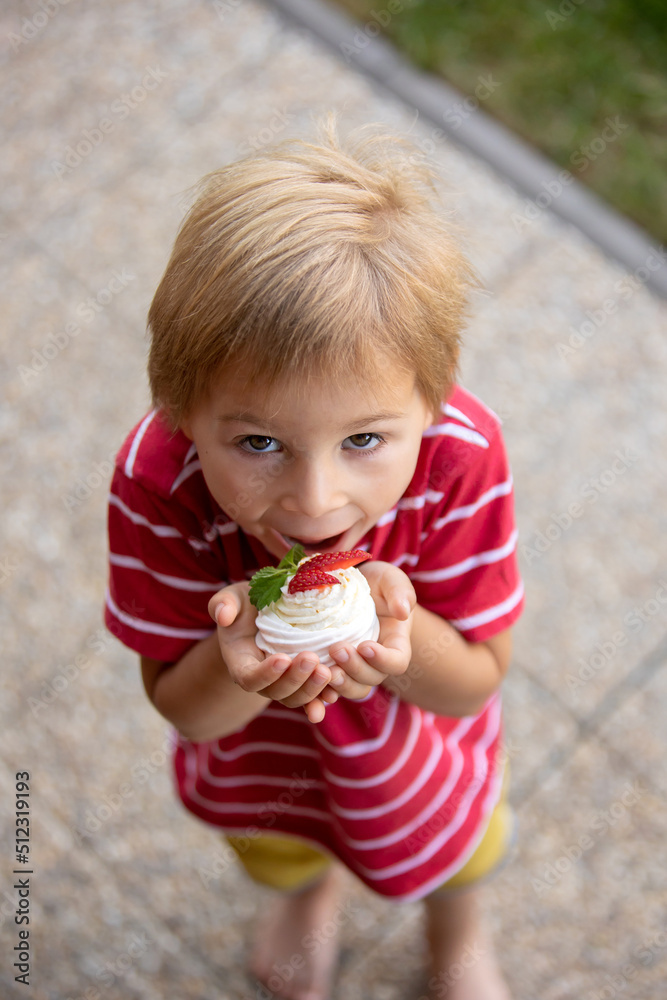 Cute child, boy, eating small cupcake of Pavlova desert, light egg and ...