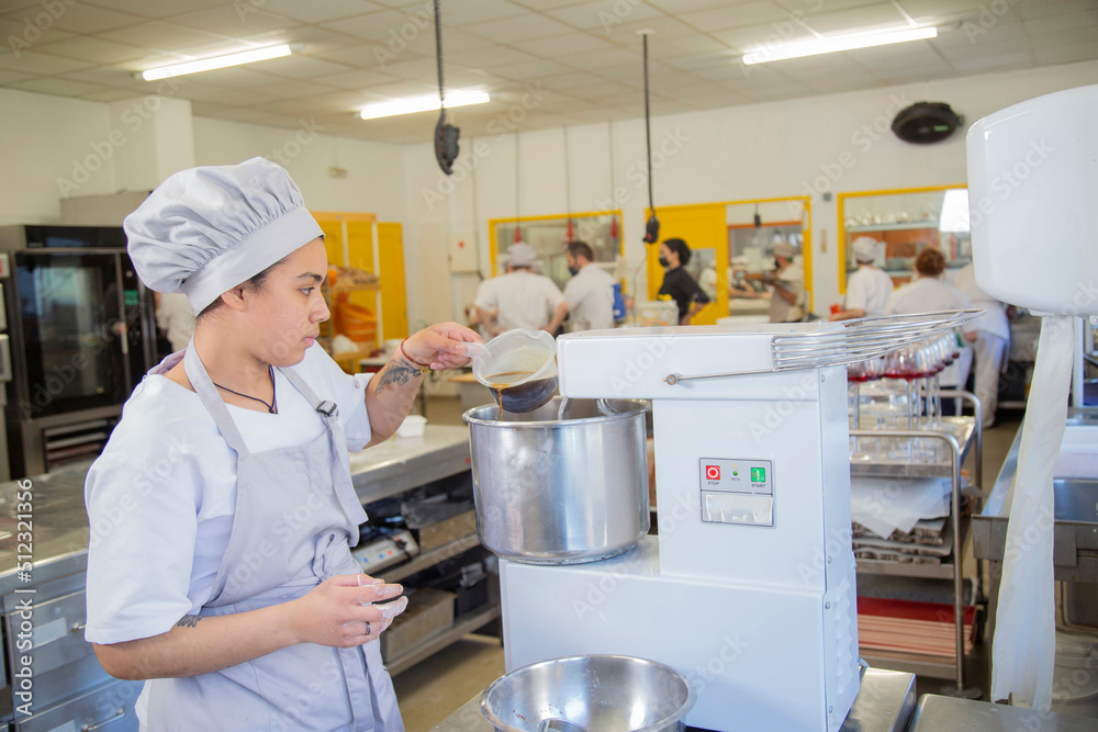 Woman pouring ingredient into mixer Stock Photo | Adobe Stock