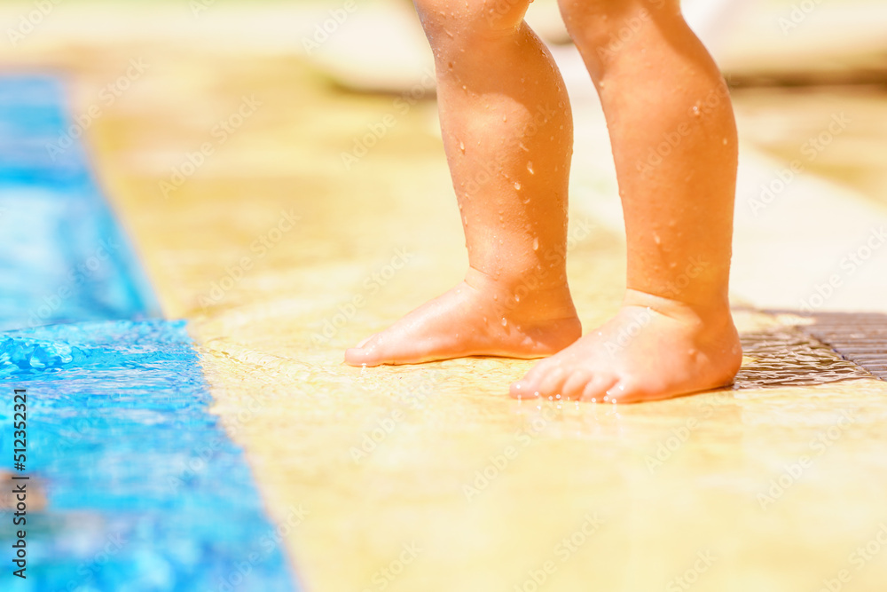 Baby's feet on the side of the pool. Outdoor entertainment in the in ...