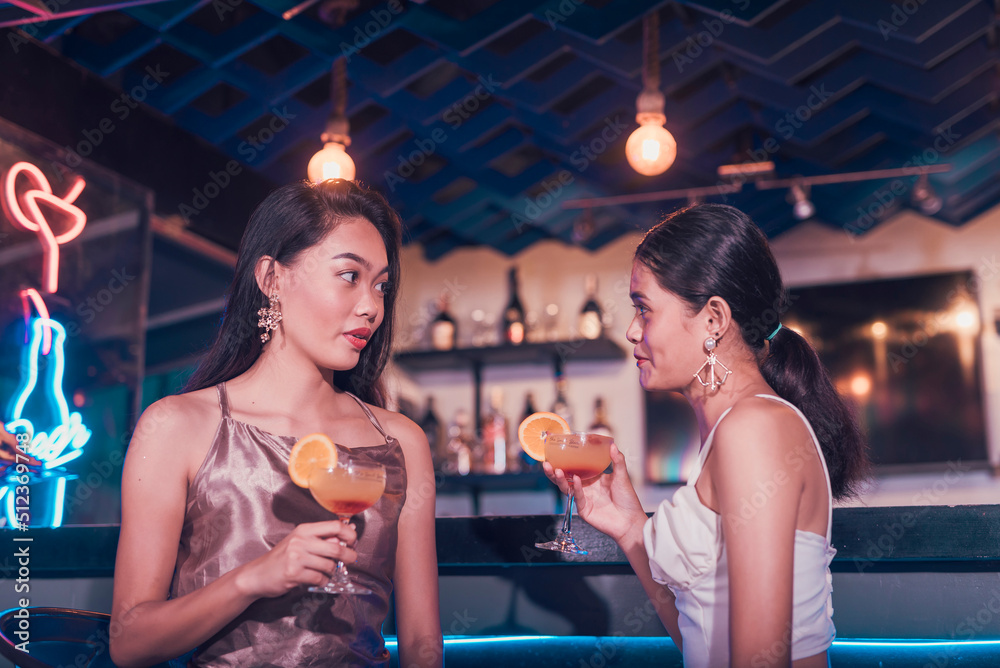 Two attractive ladies hanging out at the bar and having a great time ...