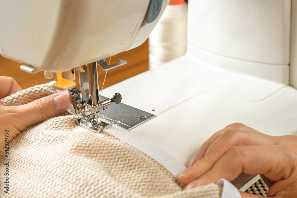 Seamstress hands holding white textile fabric. Female hands stitching ...
