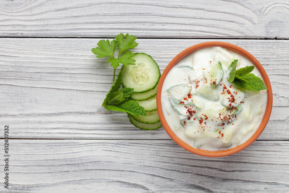 Indian Fresh sauce called Raita with herbs, dahi and sliced cucumber in ...