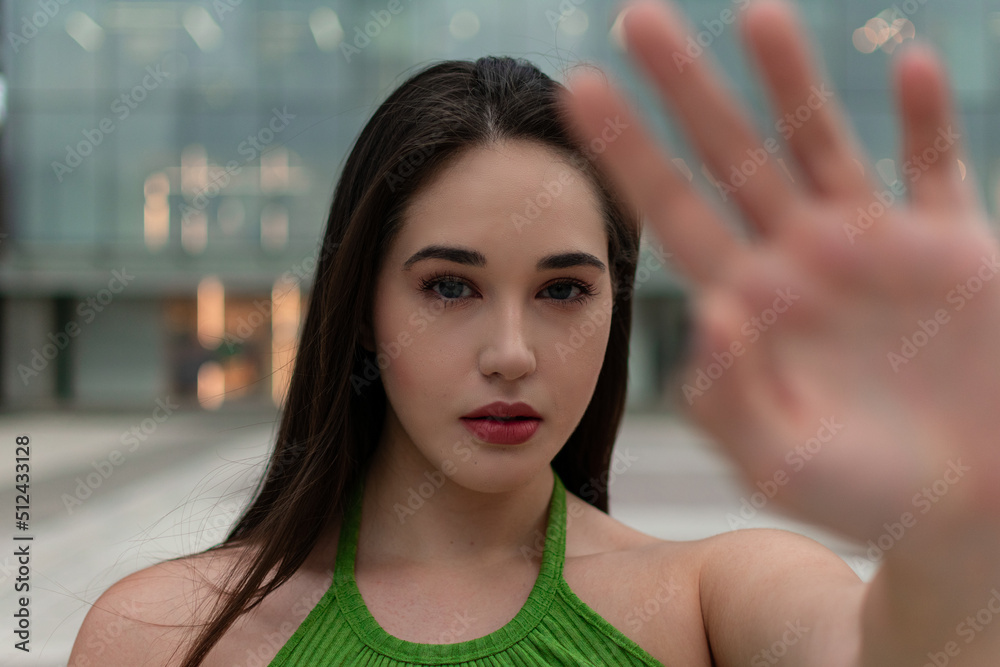 portrait of woman makes gesture with open hand, denounces assault ...