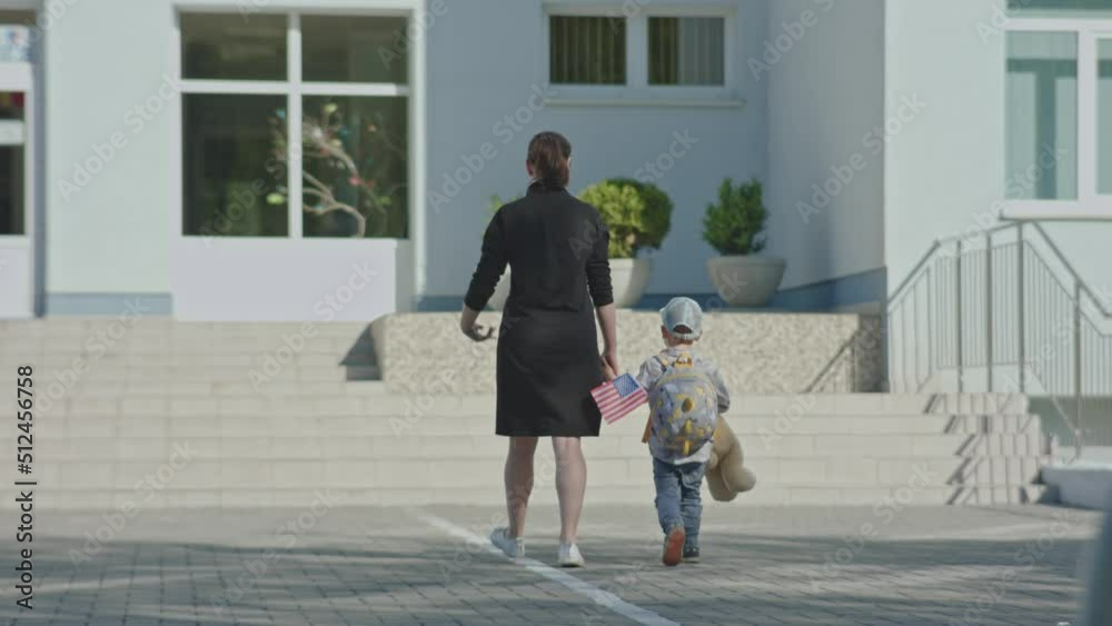 mother in black holding preschooler boy child hand taking him back to ...