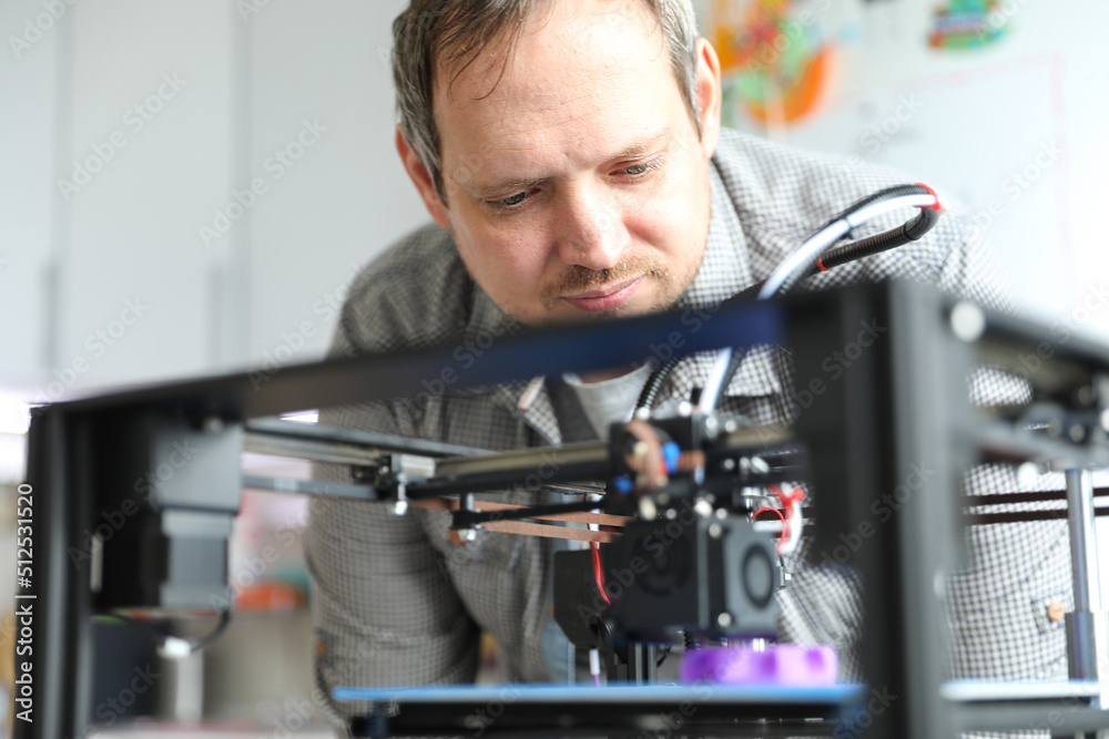 An engineer is setting up a machine for 3D printing, a printer for ...