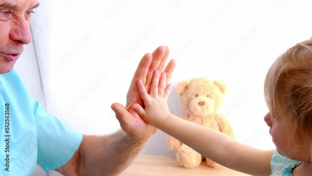 friendly male pediatrician giving high five to little patient, cute ...